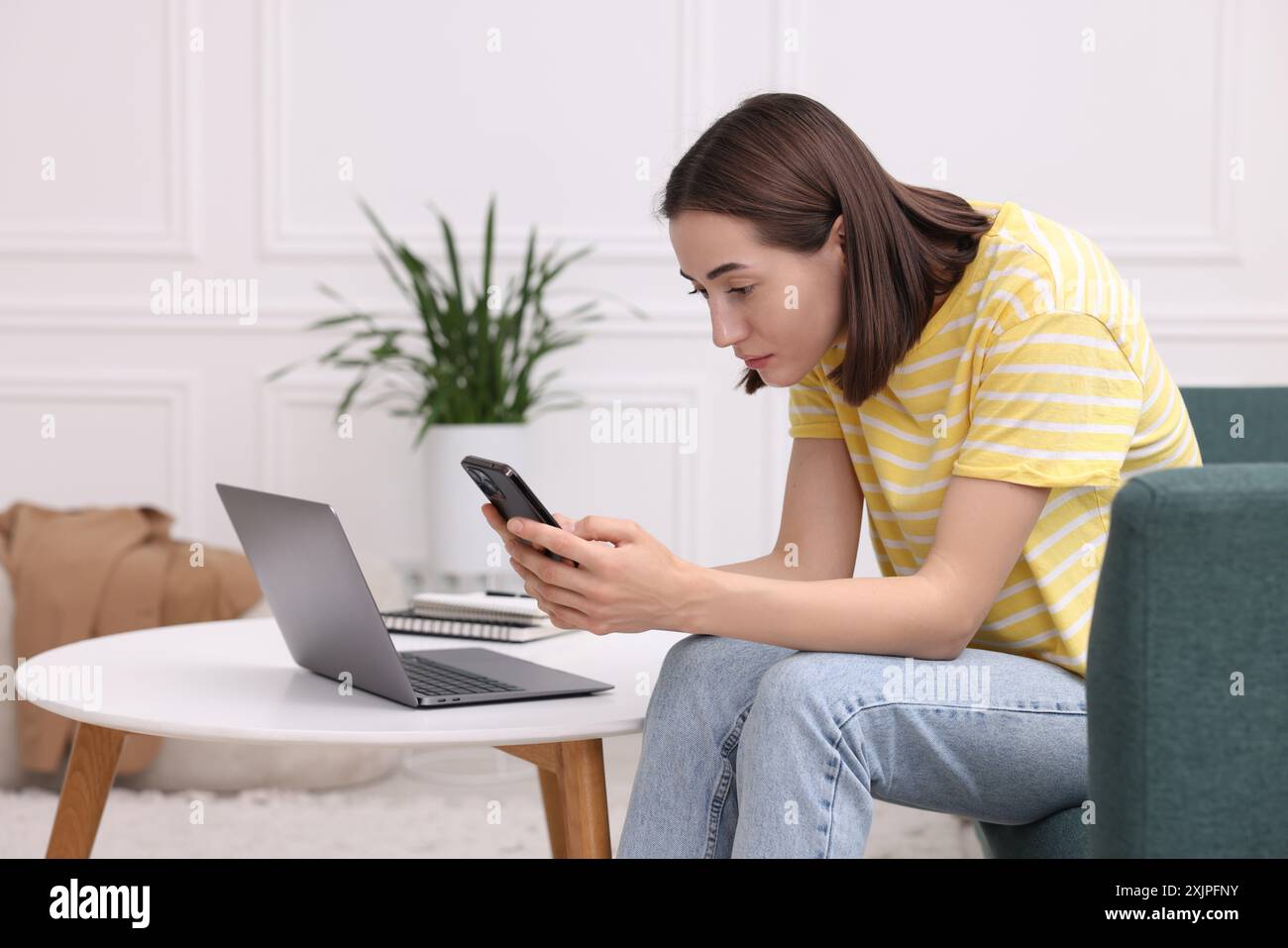 Woman with poor posture using smartphone at home Stock Photo - Alamy