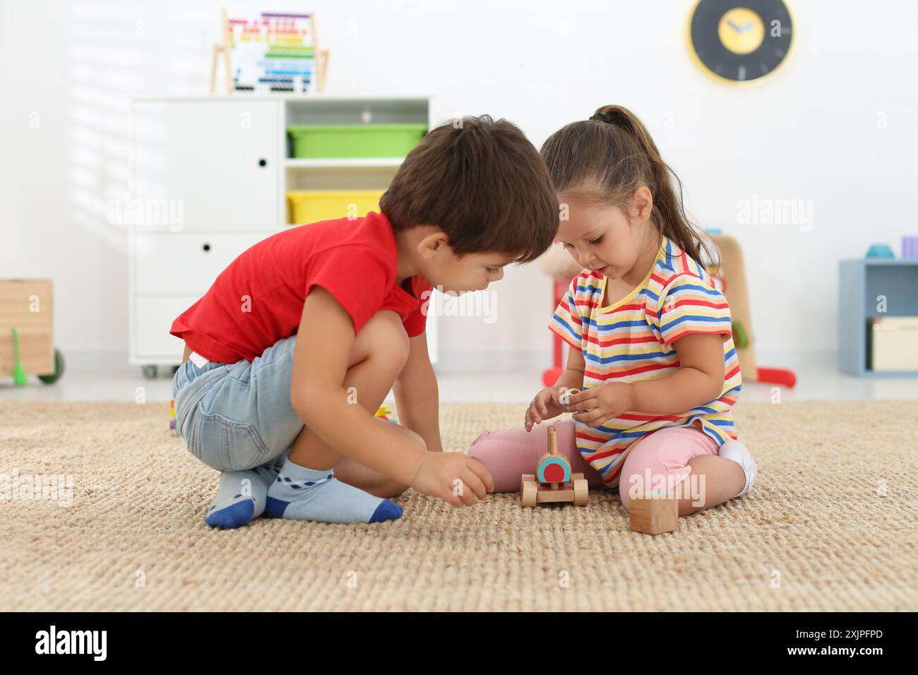 Cute little children playing with toys on floor at home Stock Photo - Alamy