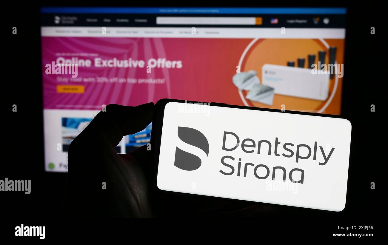 Stuttgart, Germany, 06-28-2023: Person holding cellphone with logo of US dental equipment ...
