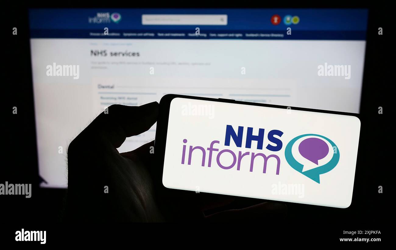 Stuttgart, Germany, 07-12-2023: Person holding mobile phone with logo of Scottish health ...