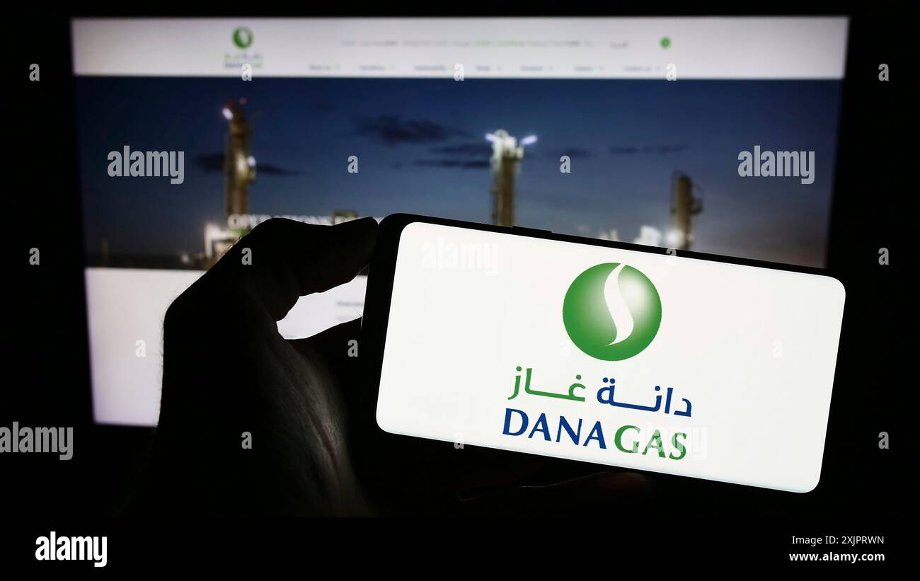 Stuttgart, Germany, 08-29-2023: Person holding mobile phone with logo of Emirati petroleum ...