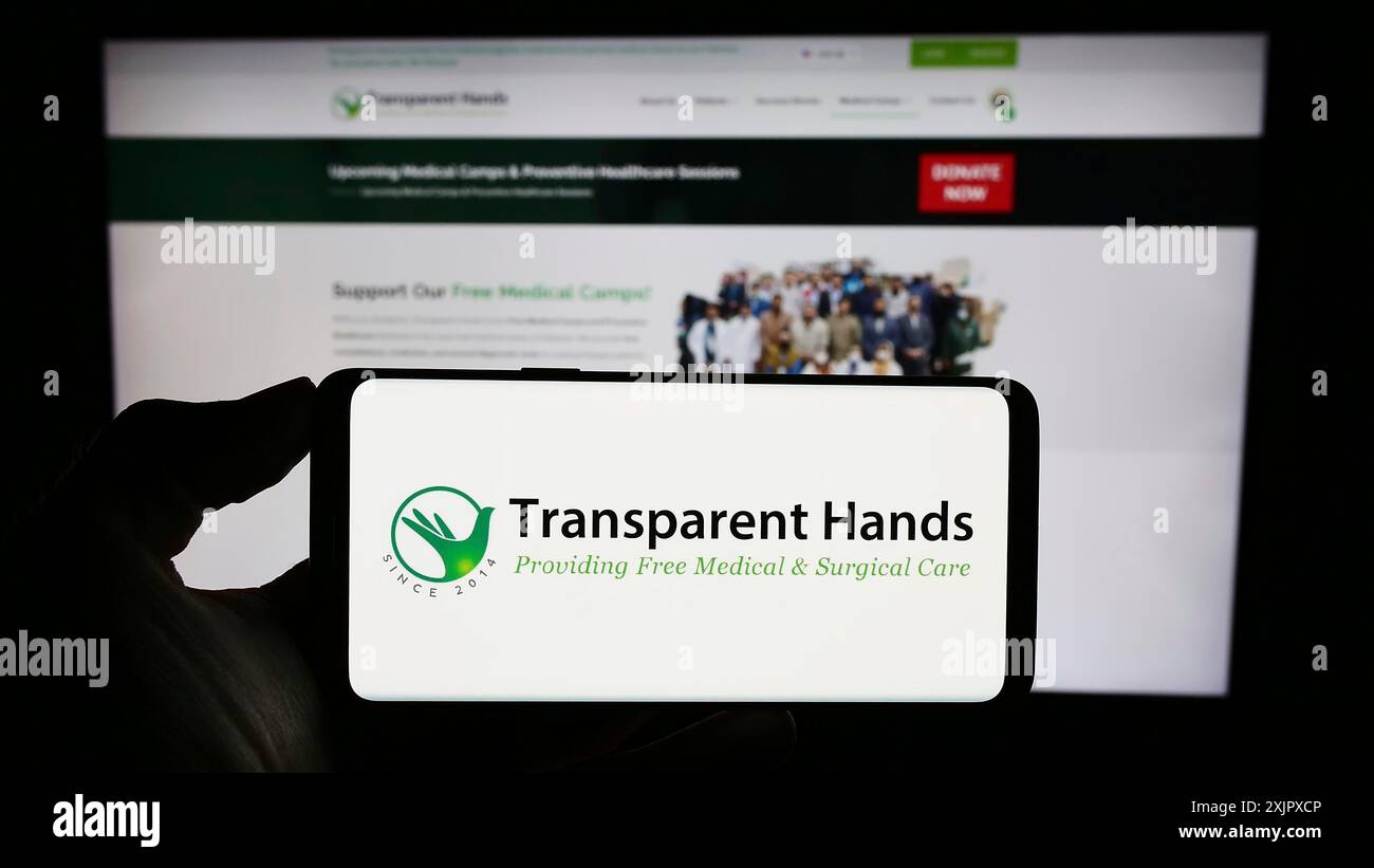 Stuttgart, Germany, 10-10-2023: Person holding cellphone with logo of US non-profit organization ...