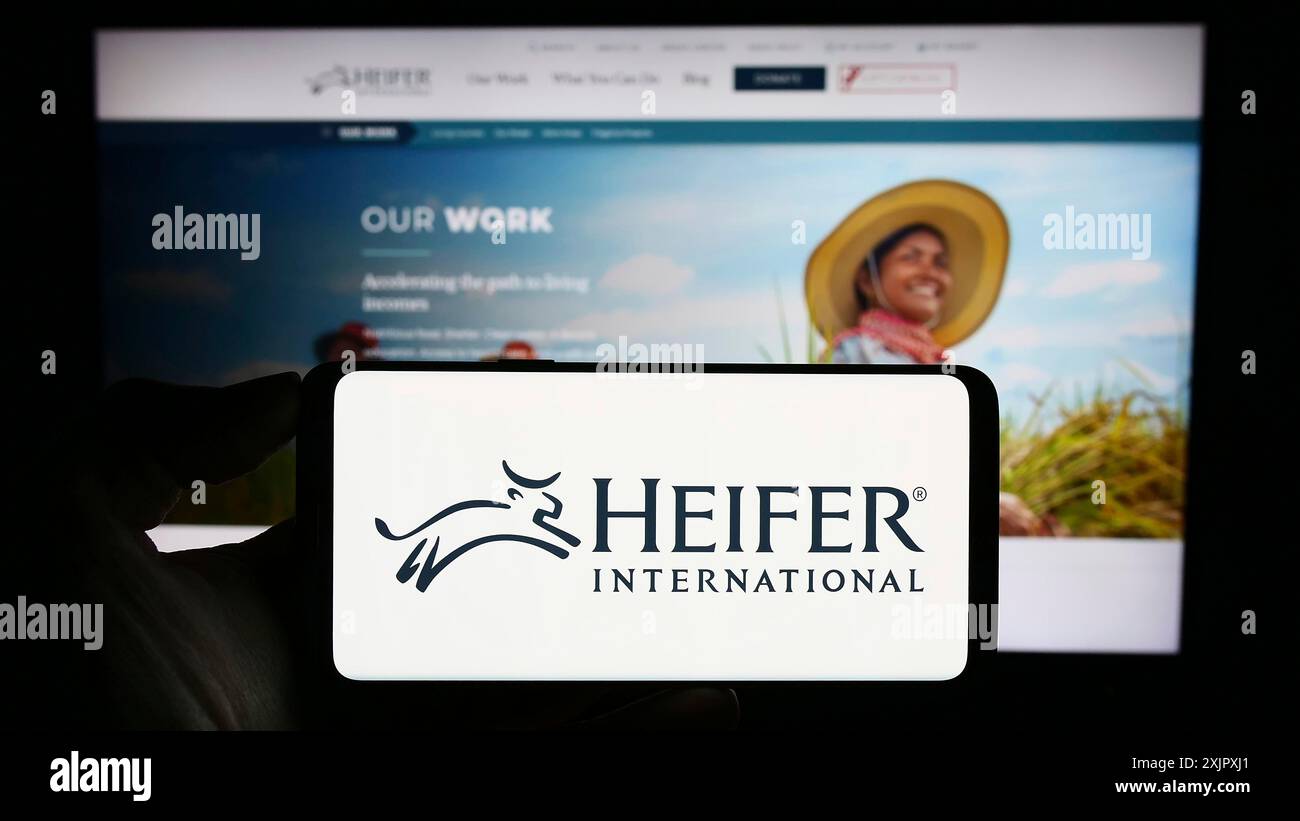 Stuttgart, Germany, 10-11-2023: Person holding cellphone with logo of development organization ...