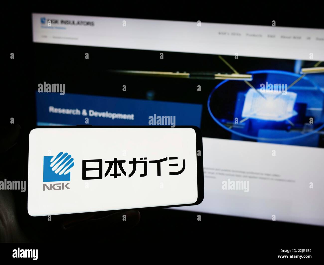 Stuttgart, Germany, 11-15-2023: Person holding cellphone with logo of Japanese ceramics company ...