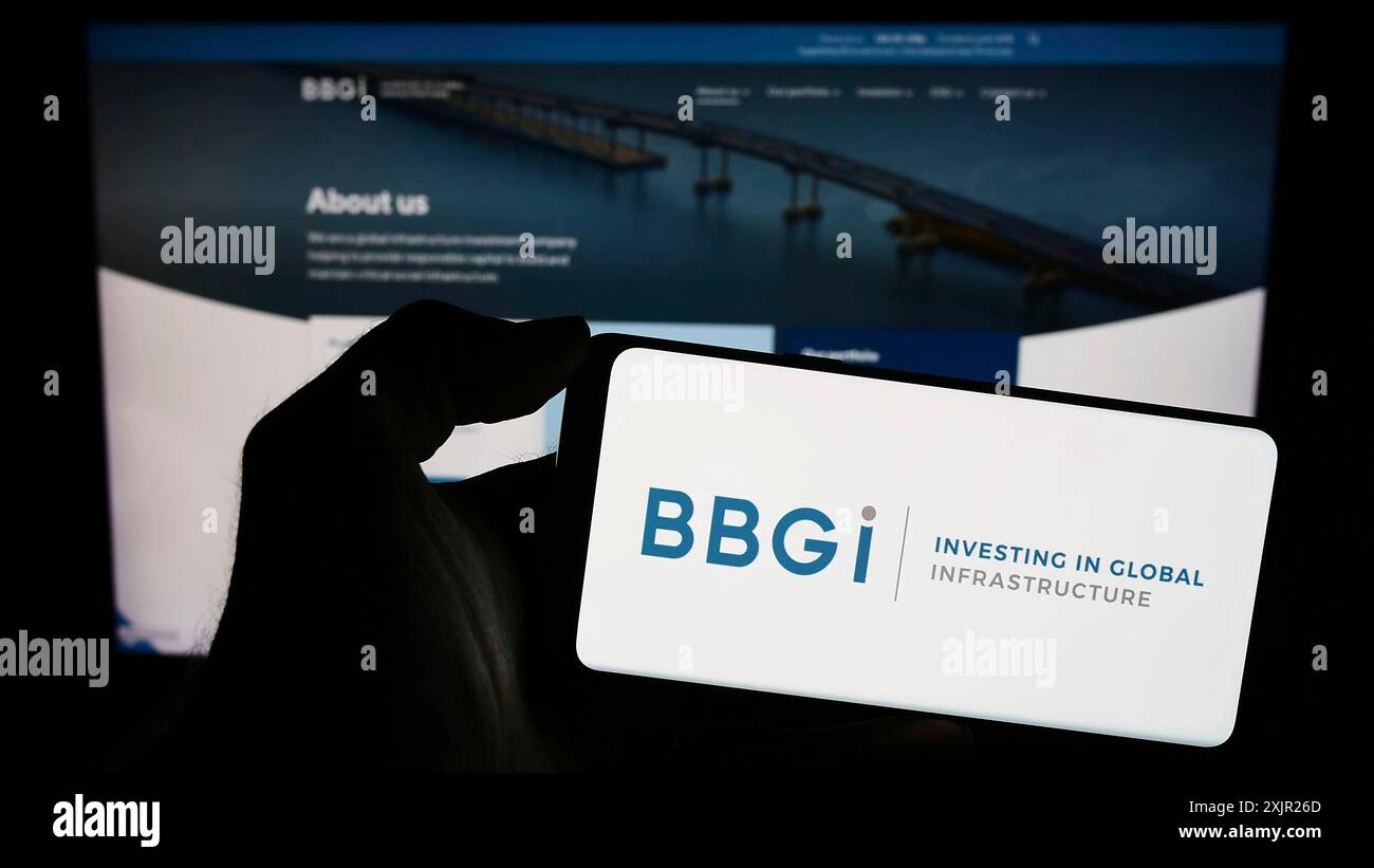 Stuttgart, Germany, 12-02-2023: Person holding smartphone with logo of investment company BBGI ...