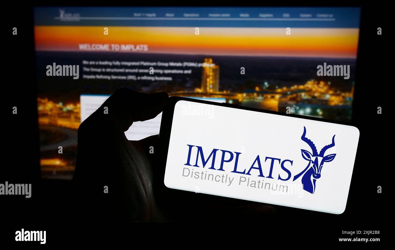 Stuttgart, Germany, 12-07-2023: Person holding mobile phone with logo of company Impala Platinum ...