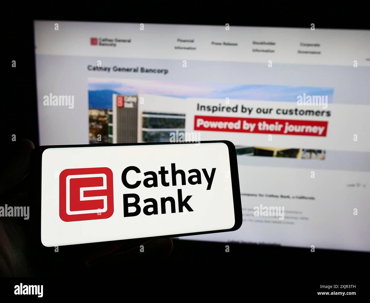 Stuttgart, Germany, 12-23-2023: Person holding smartphone with logo of US company Cathay General ...