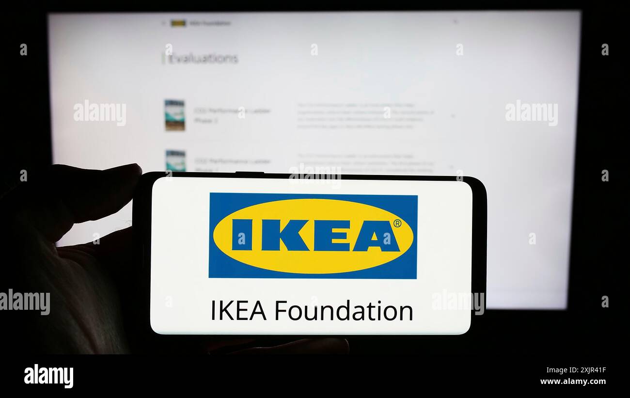 Stuttgart, Germany, 12-29-2023: Person holding cellphone with logo of organization IKEA ...