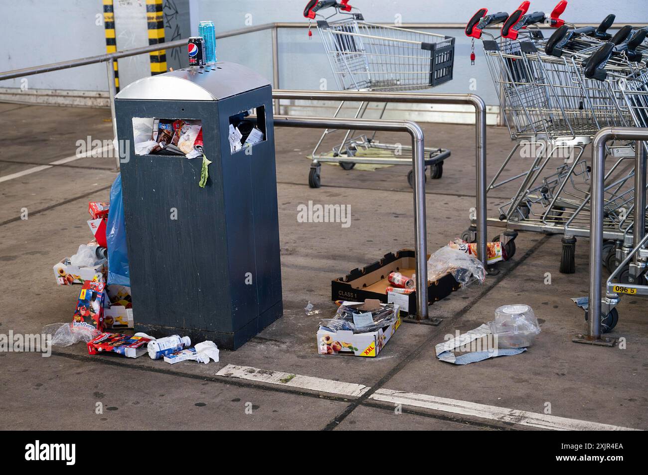 Overflowing dumpster, trash can with plastic bags and cardboard, filthy ...
