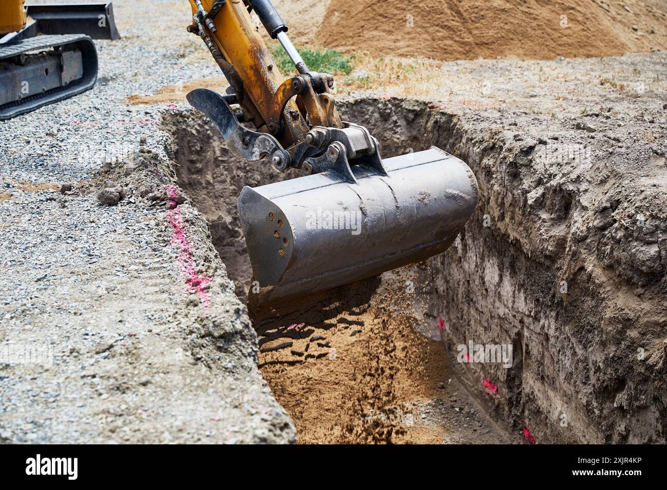 Steel Mini Bucket on the arm of an Excavator putting sand in a deep ...