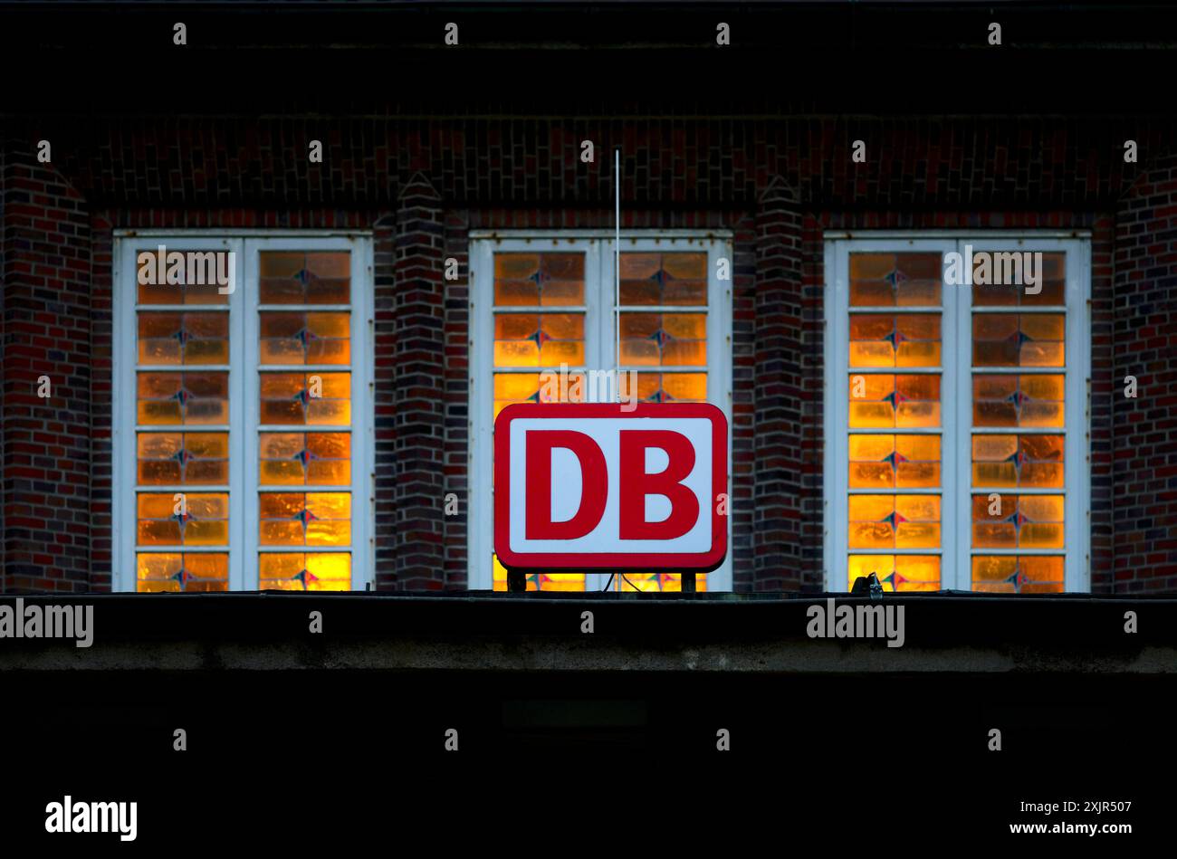 DB Deutsche Bahn logo, windows light up from inside, atmospheric, Westerland railway station ...