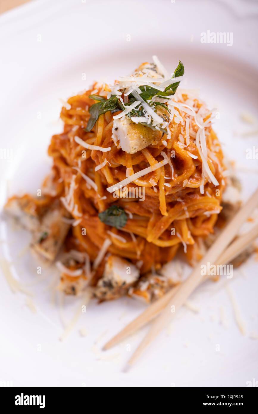 A beautifully plated tower of spaghetti coated in a rich tomato sauce ...