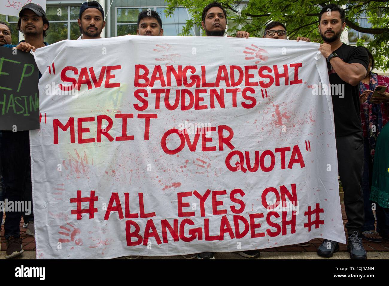 Bangladeshi people holding a sign with Save Bangladeshi Students, Merit ...