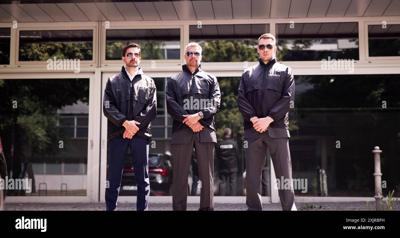 Professional security guard overseeing event safety with his team of ...