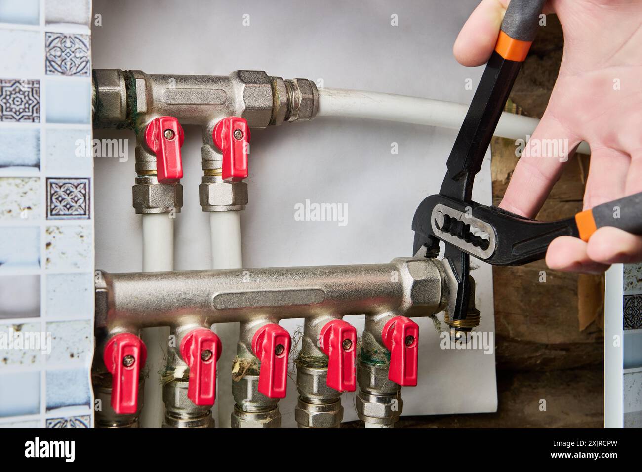 Using adjustable pliers for plumbing work in country house, plumber ...