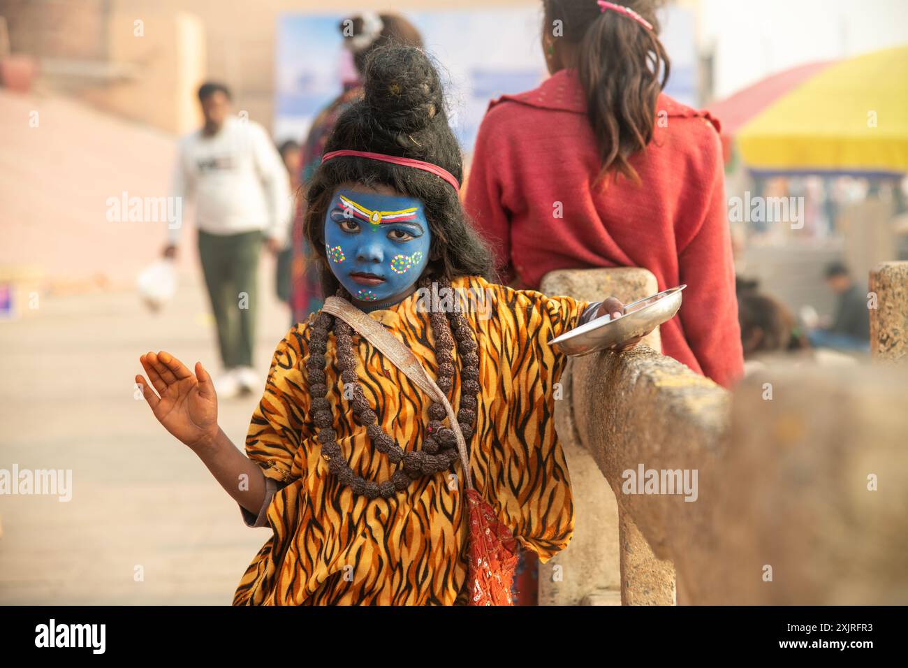 Portrait of a poor kid dressed as Lord Shiva and Goddess Parvati with a ...