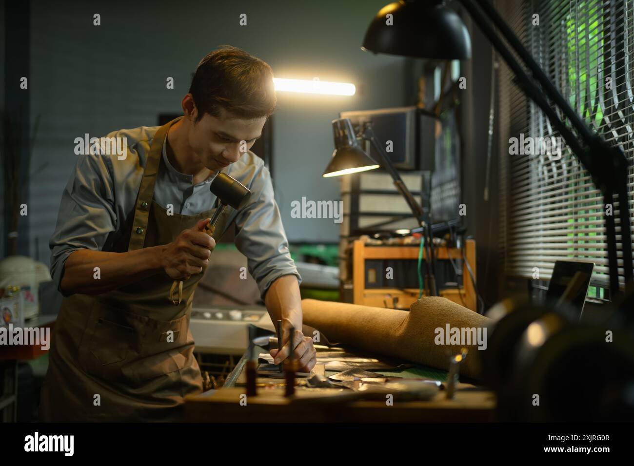 Professional craftsman using a hammer and other tools to shape and ...