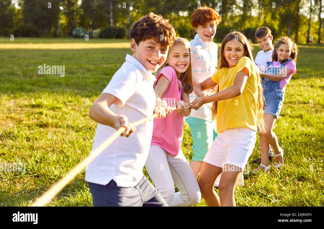 Group of happy children having fun together and playing tug of war in ...