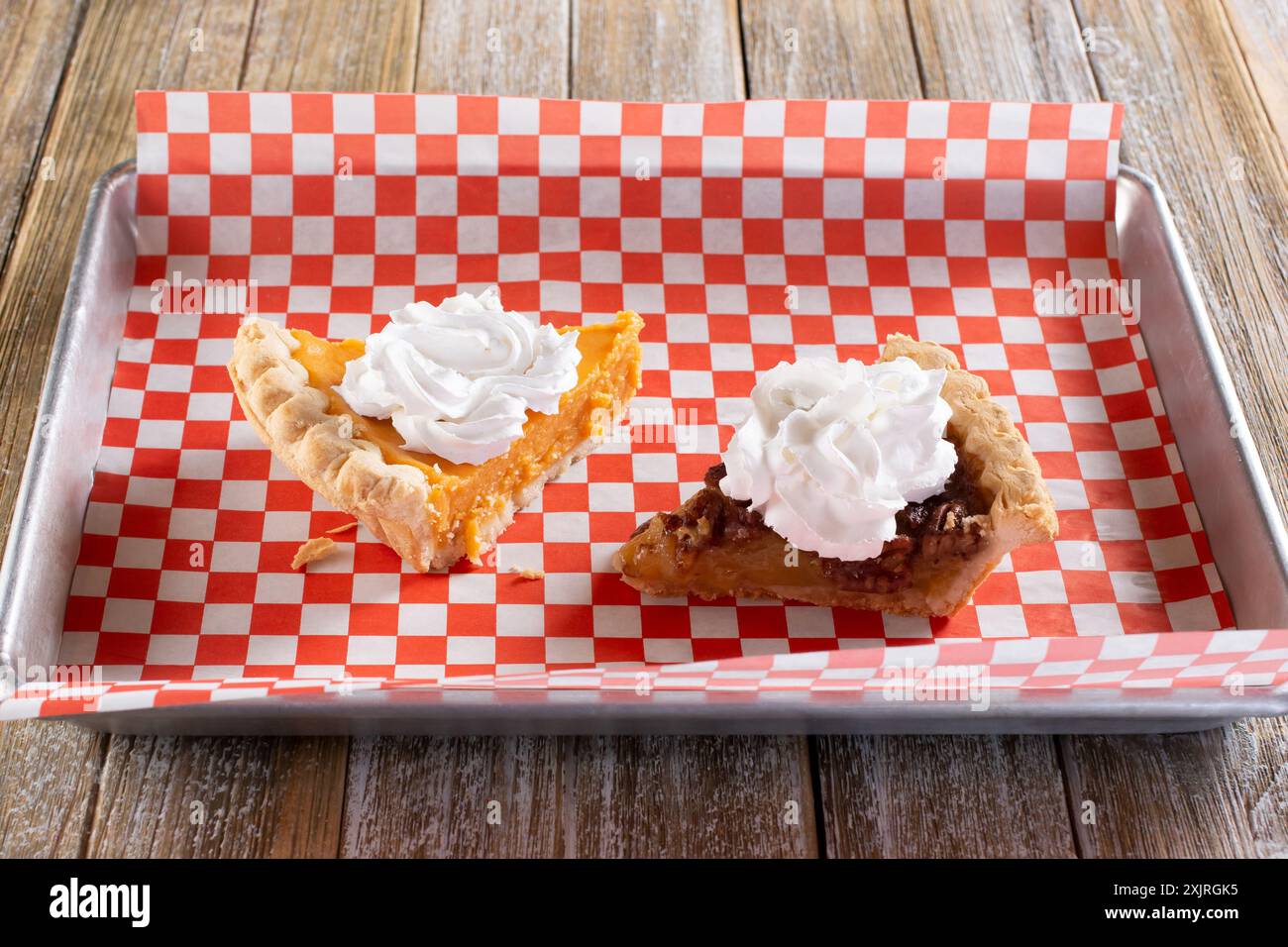 A view of a lined tray featuring a slice of sweet potato pie and pecan ...