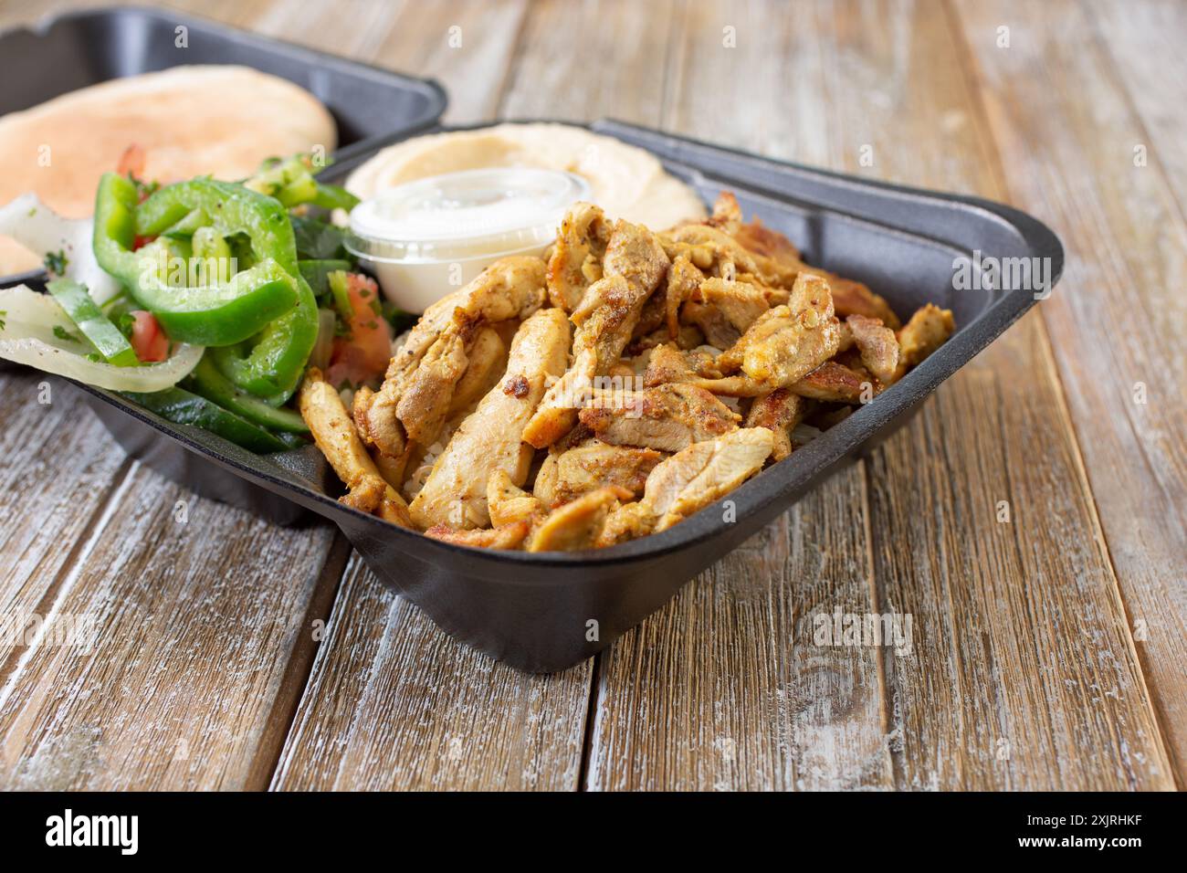 A view of a chicken shawarma combo in a styrofoam to-go container Stock ...