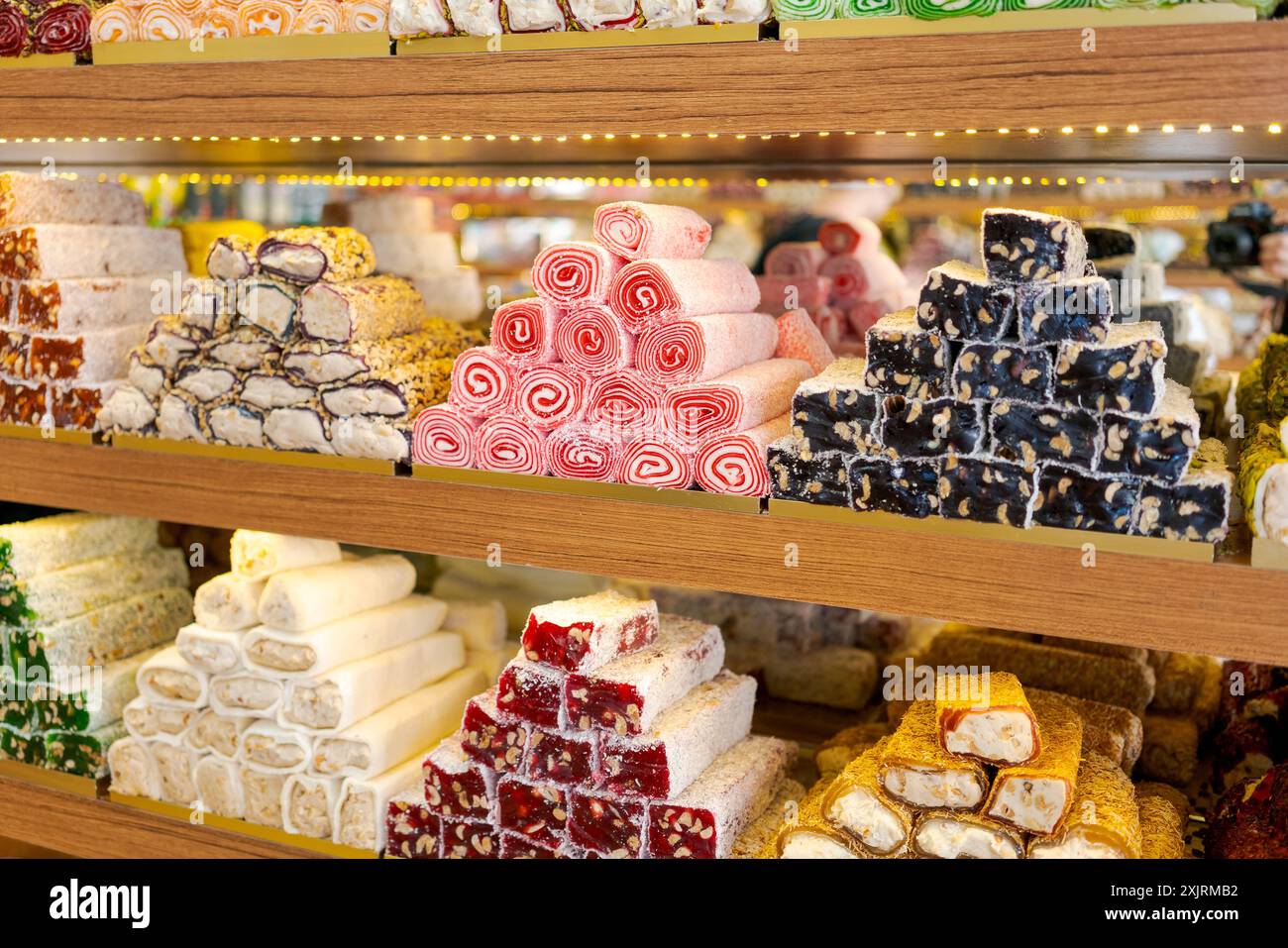 Various types of Turkish delight sweets arranged in pyramids on wooden ...