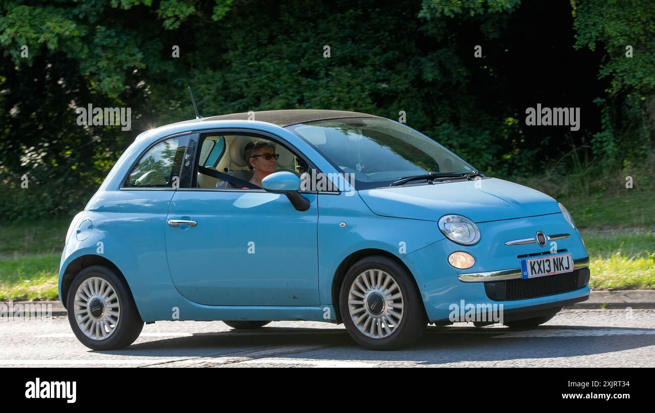 Milton Keynes,UK - July 18th 2024: 2013 blue Fiat 500 car driving on a British country road ...