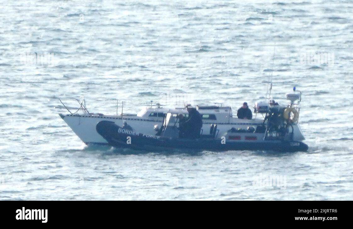 A Border Force vessel tows a yacht in to Dover marina in Kent ...