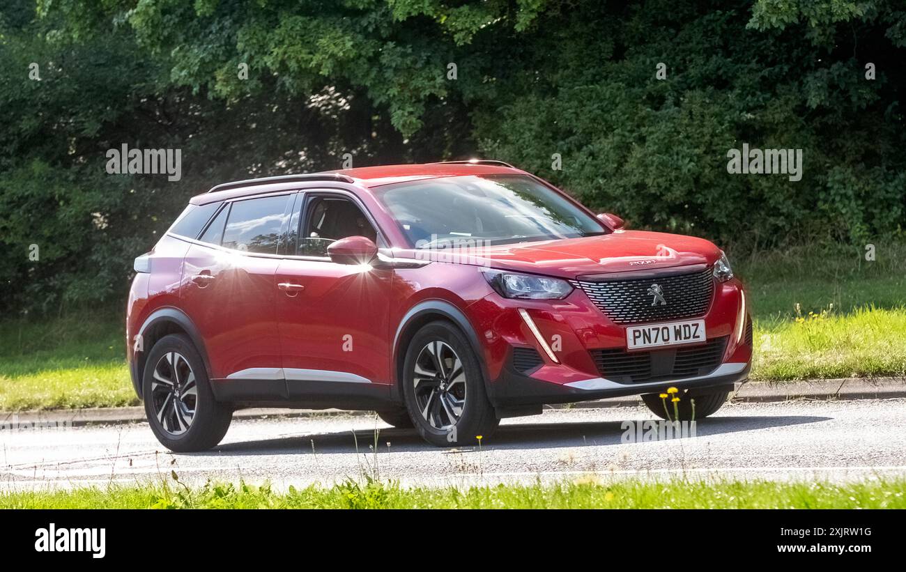 Milton Keynes,UK - July 18th 2024: 2021 red Peugeot 2008 car driving on a British country road ...