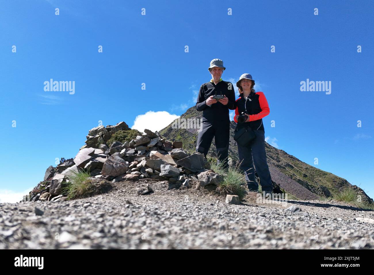A senior couple hiking in the mountains of the Pyrenees and operating a ...