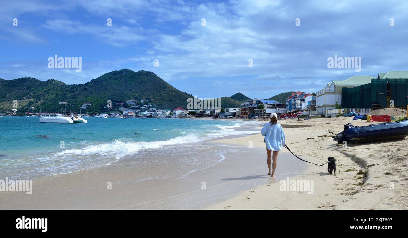 Orient Bay, St Maarten - 2nd February 2024:Lady walking her dog on ...