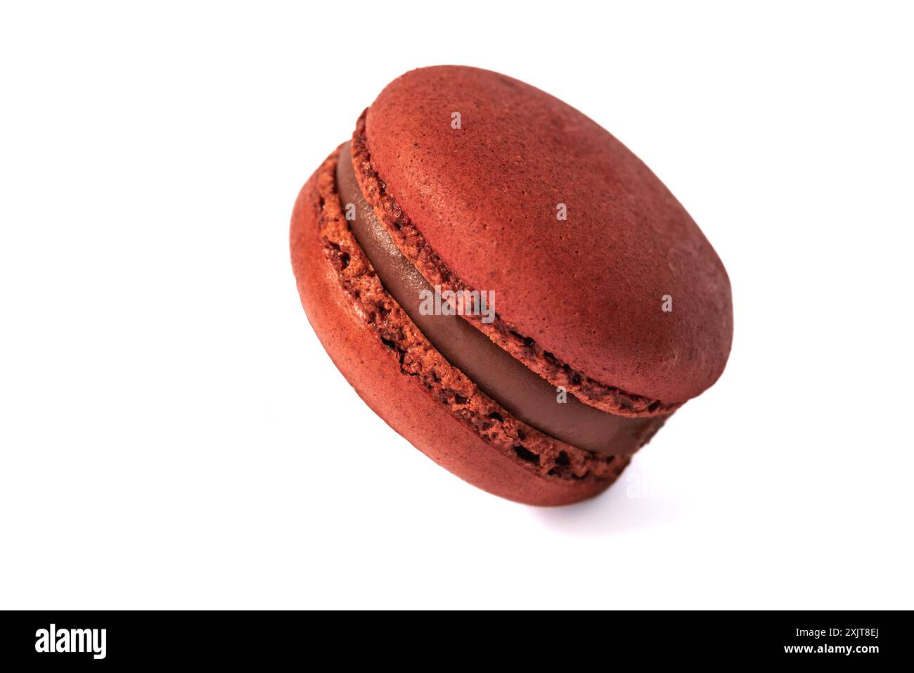 A single, red macaron with a strawberry filling is shown in a close-up ...