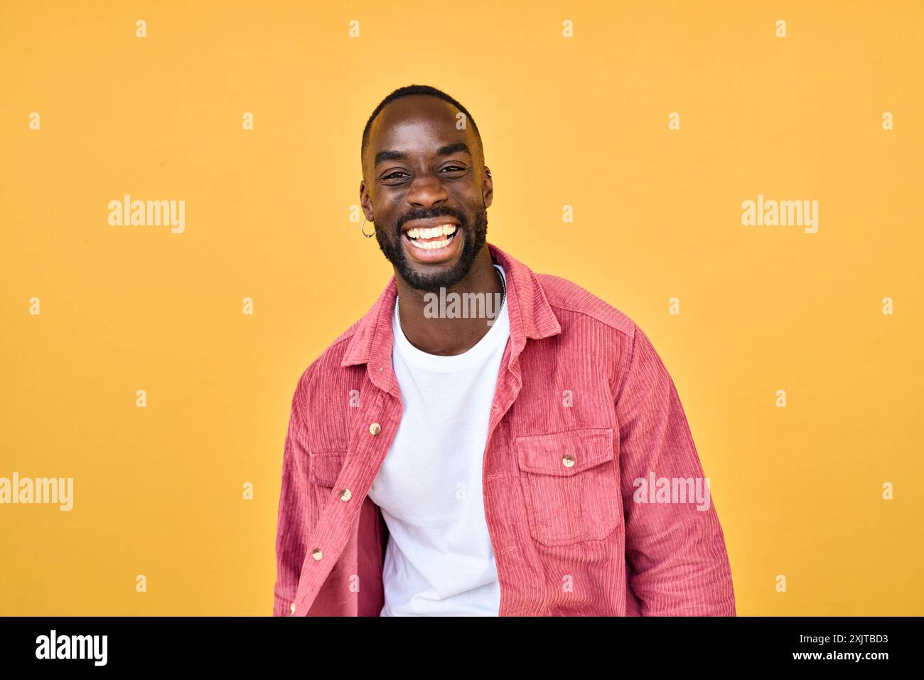 Happy cheerful cool gen z Black hipster guy standing at yellow wall ...