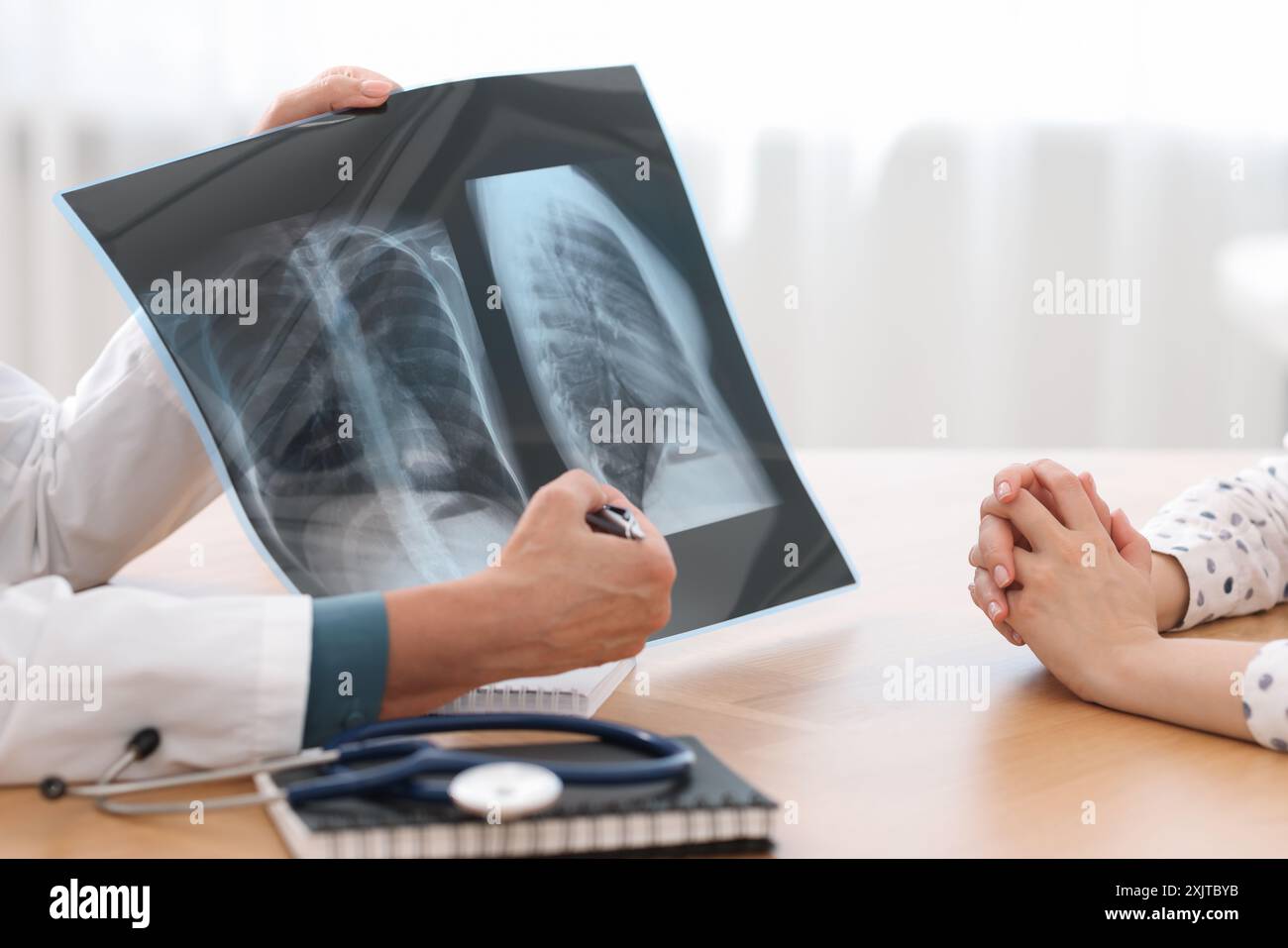 Lung disease. Doctor showing chest x-ray to her patient in clinic ...