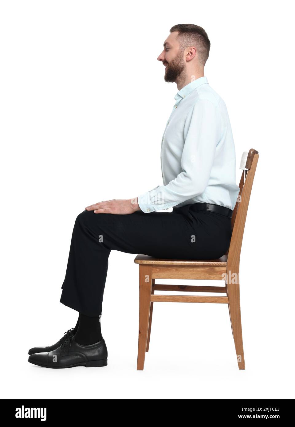 Man with good posture sitting on chair against white background Stock ...