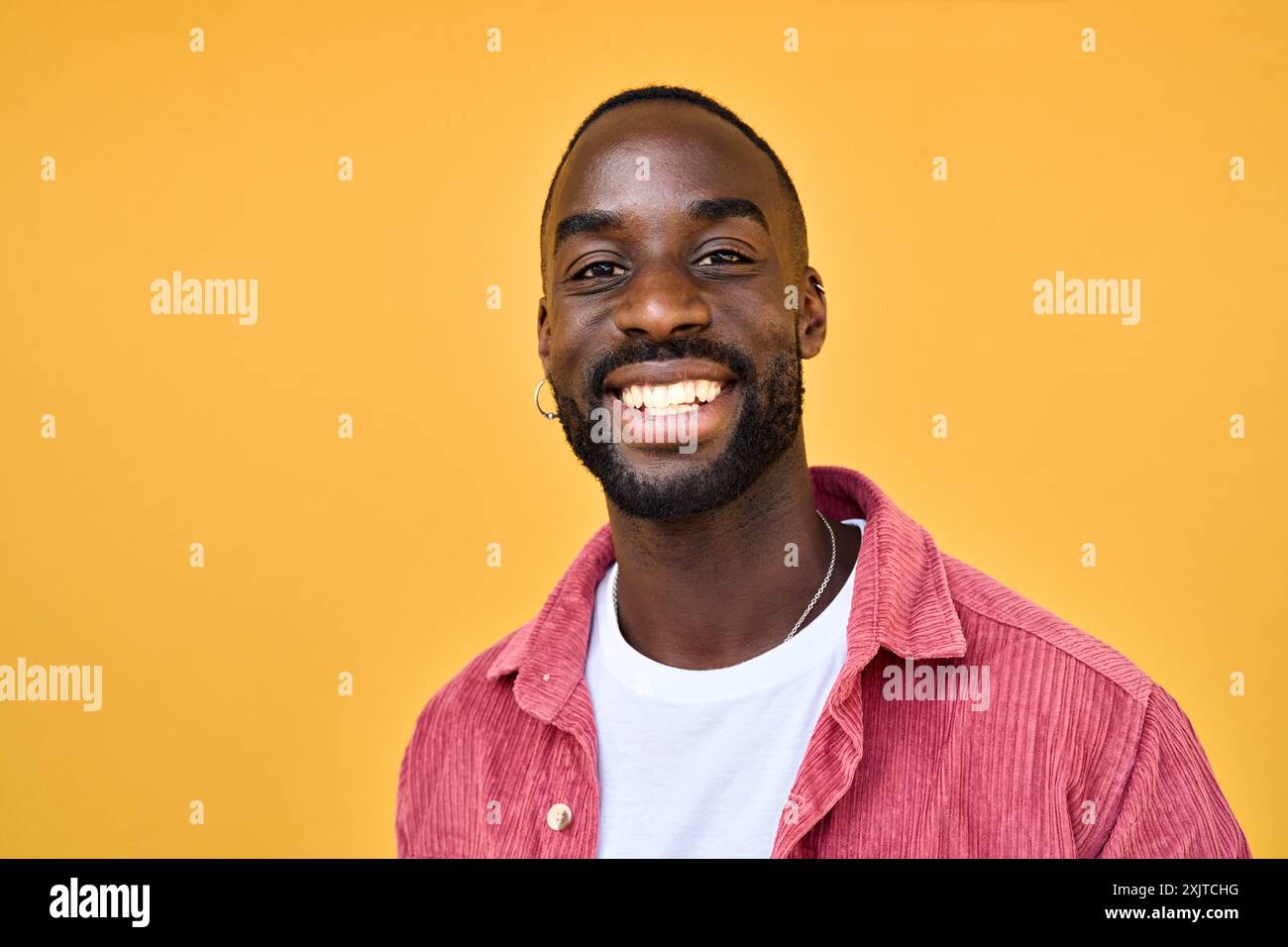 Happy cheerful cool gen z Black hipster guy standing at yellow wall ...