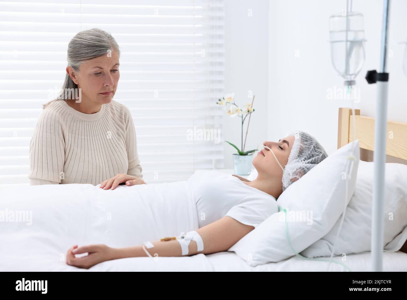 Coma patient. Sad mature woman near her unconscious daughter in ...
