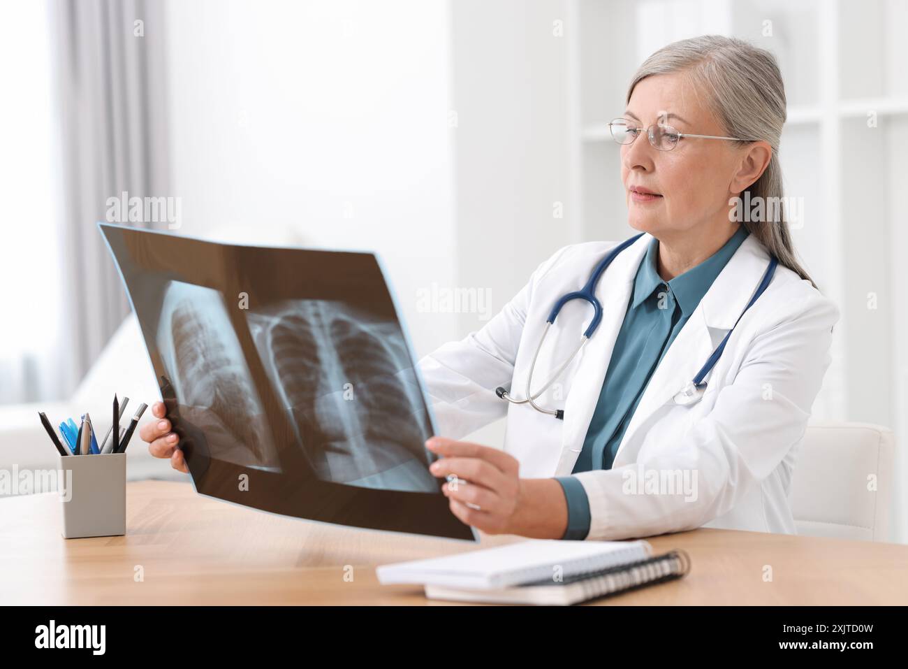 Lung disease. Doctor examining chest x-ray at table in clinic Stock ...