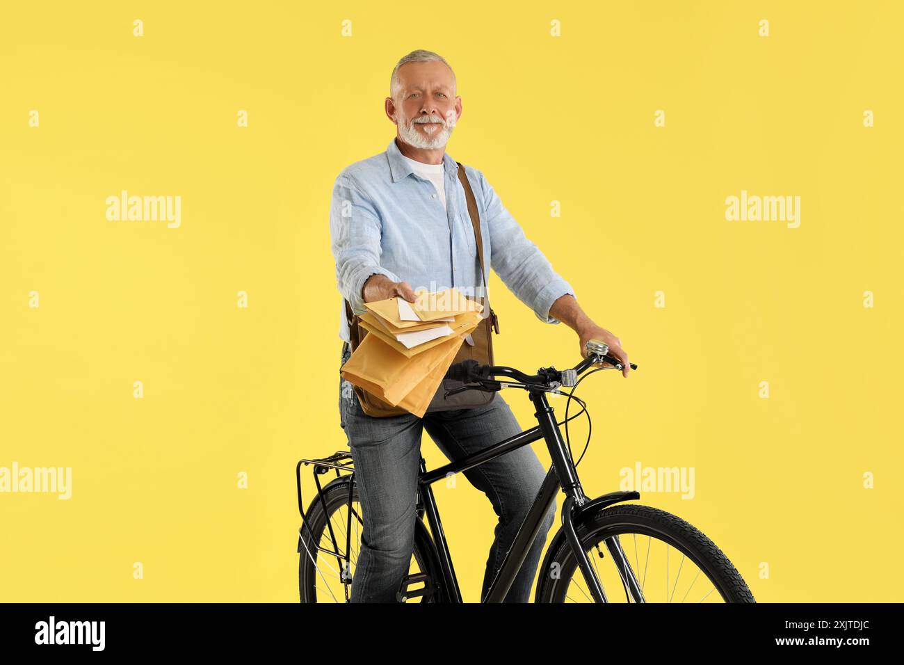 Happy postman on bicycle delivering letters against yellow background ...