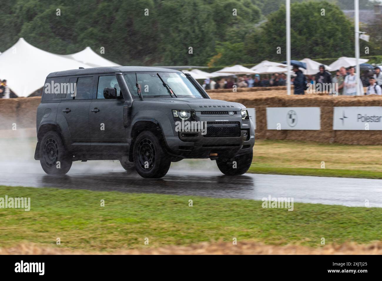 2024 Land Rover Defender OCTA driving up the hill climb track in heavy ...