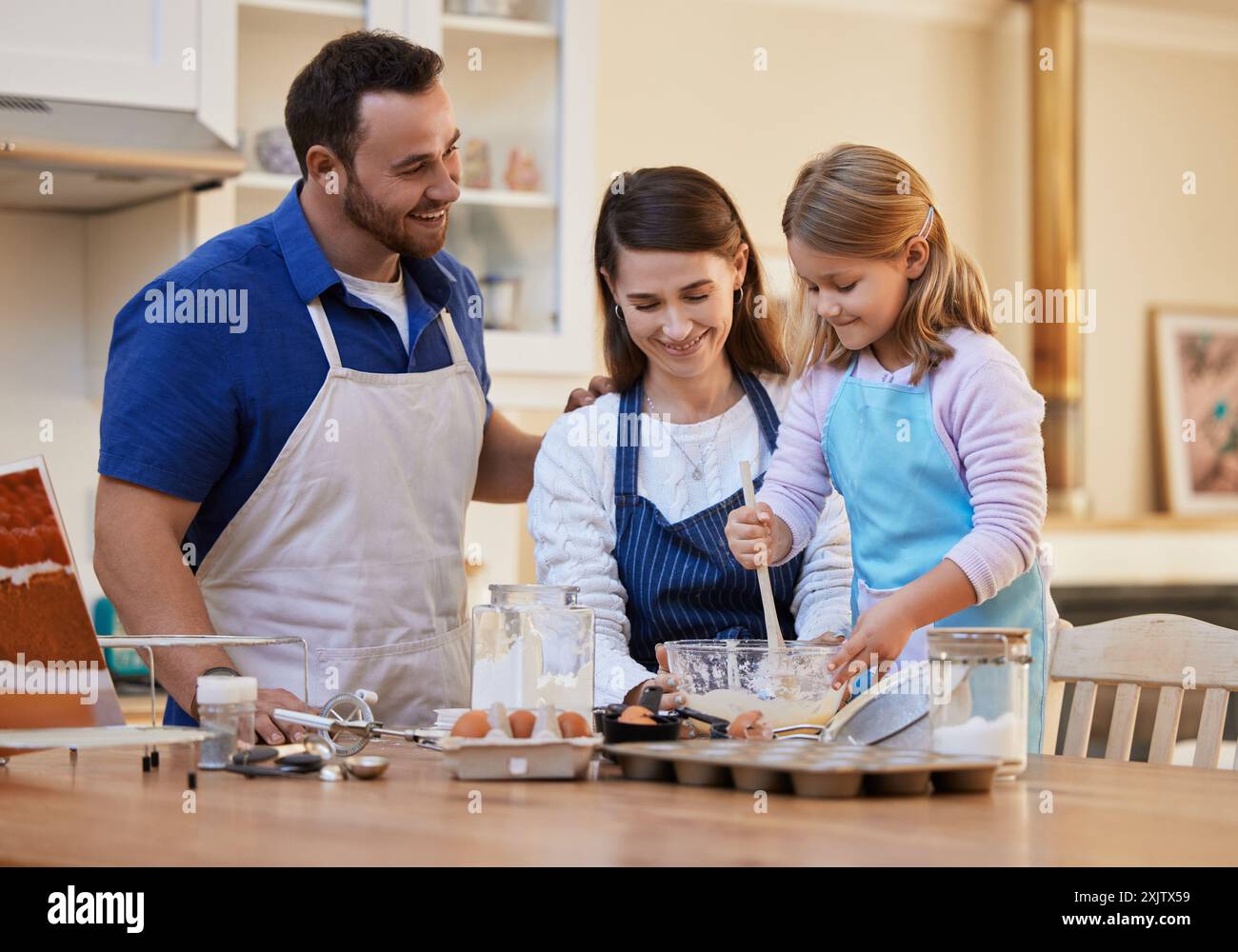Mom, dad and child baking in kitchen with recipe for bonding, learning ...