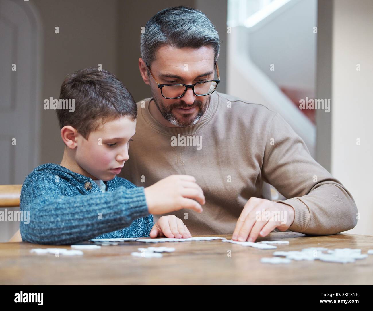 Family, man and kid with puzzle by table at home for development ...