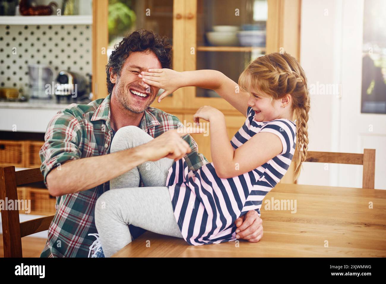 Care, love and father play with child for bonding in kitchen together ...