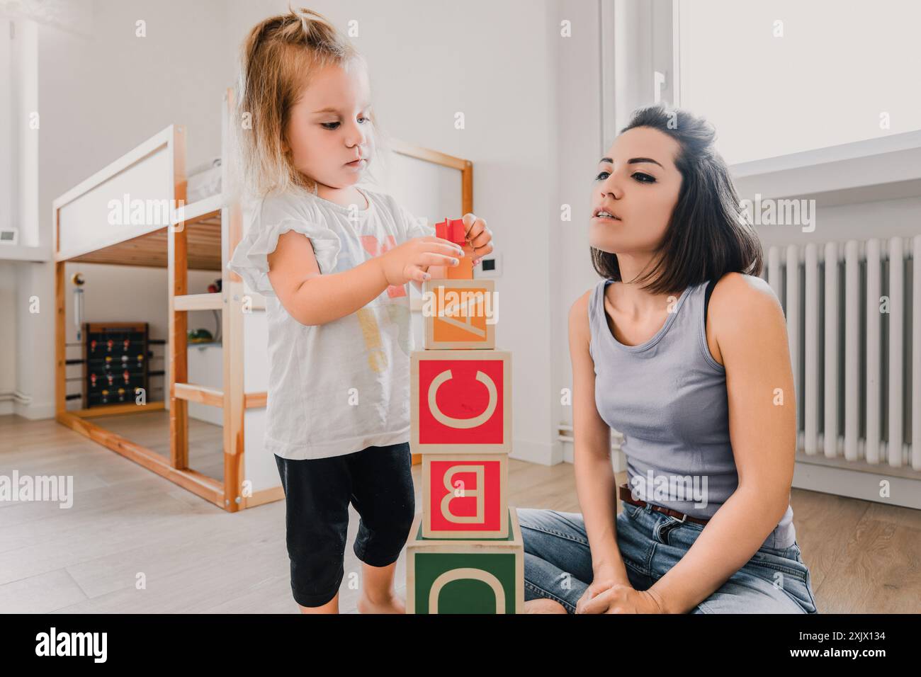 Young girl is completely absorbed in carefully placing a red letter ...