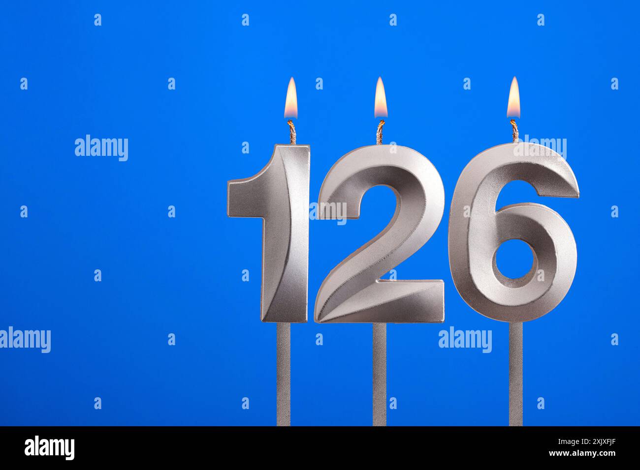 Birthday number 126 - Candle lit on blue background Stock Photo - Alamy