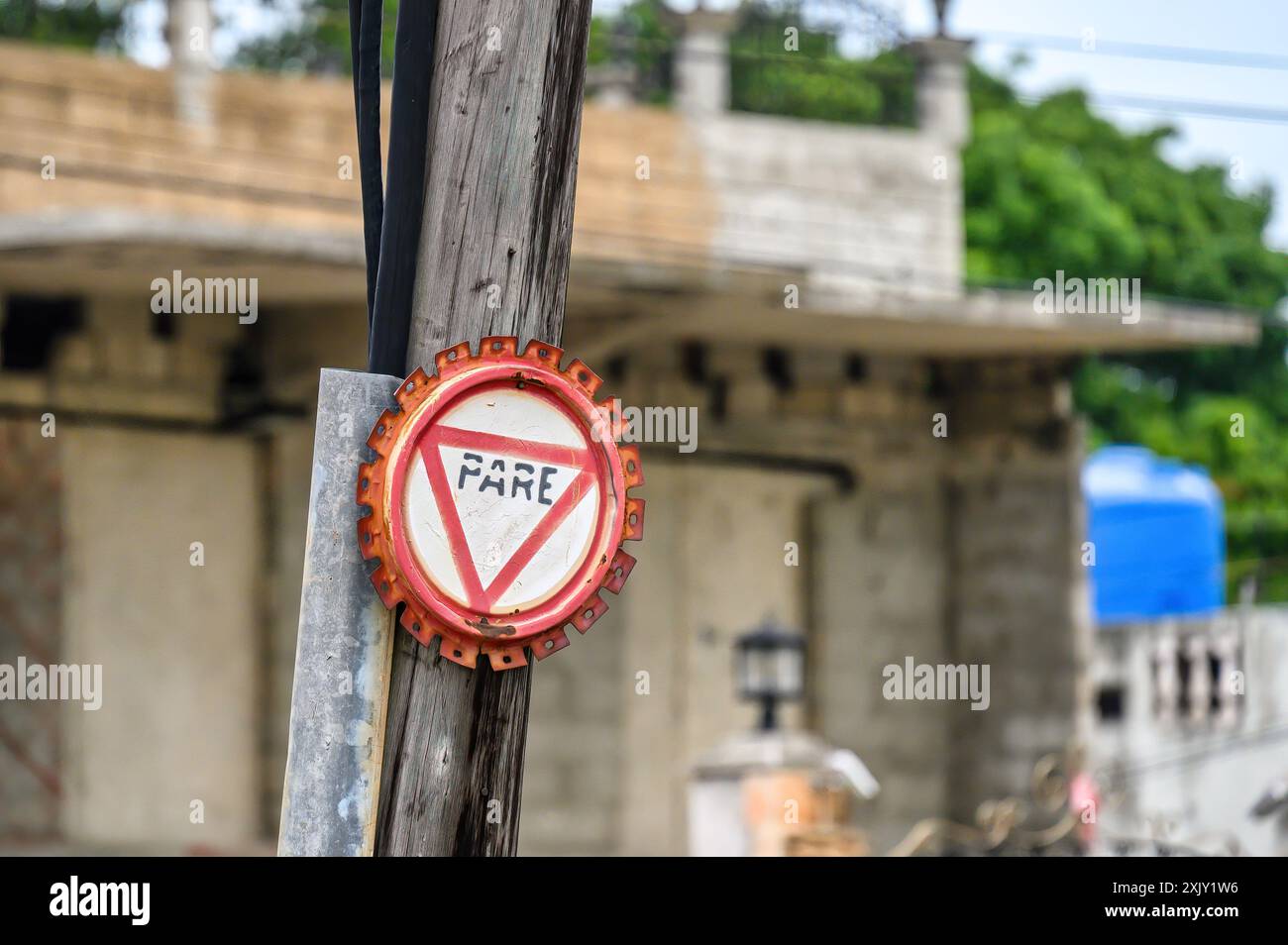 A road sign made with a lid of a storage tank. An unfinished house in ...