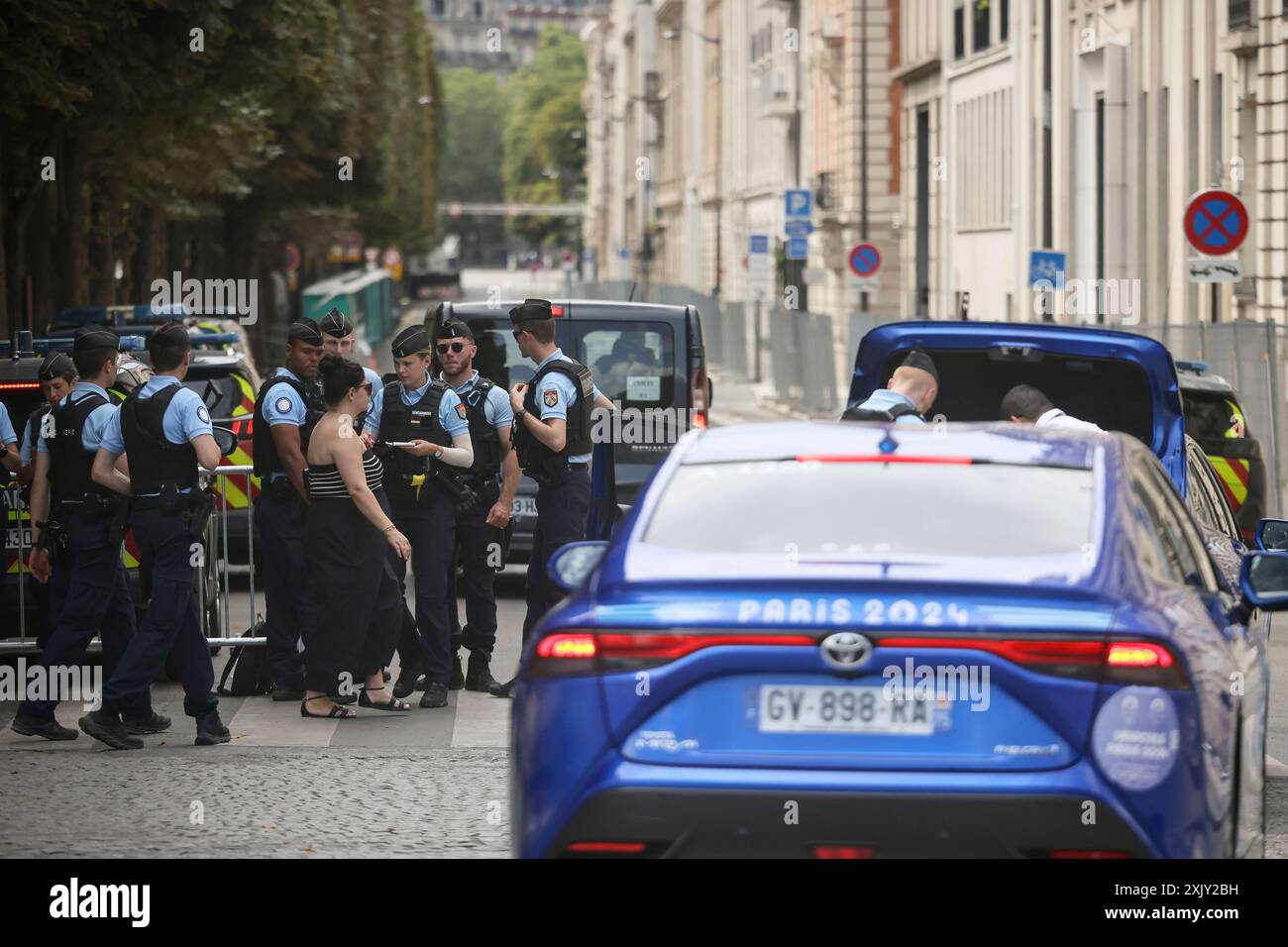 Police officers check a pedestrian and an accredited vehicle for Paris ...