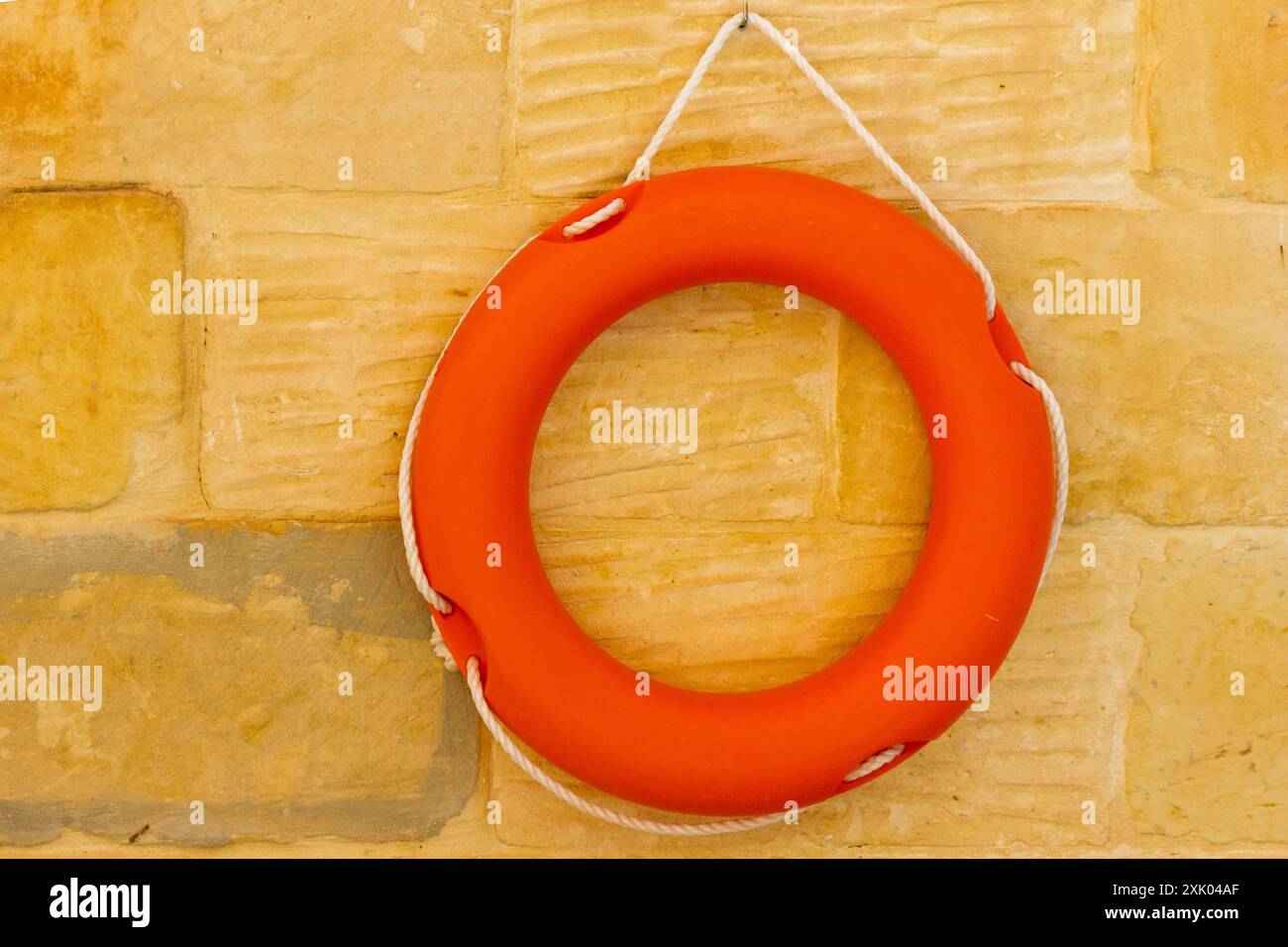 an orange lifebuoy on the stone wall by the pool Stock Photo - Alamy