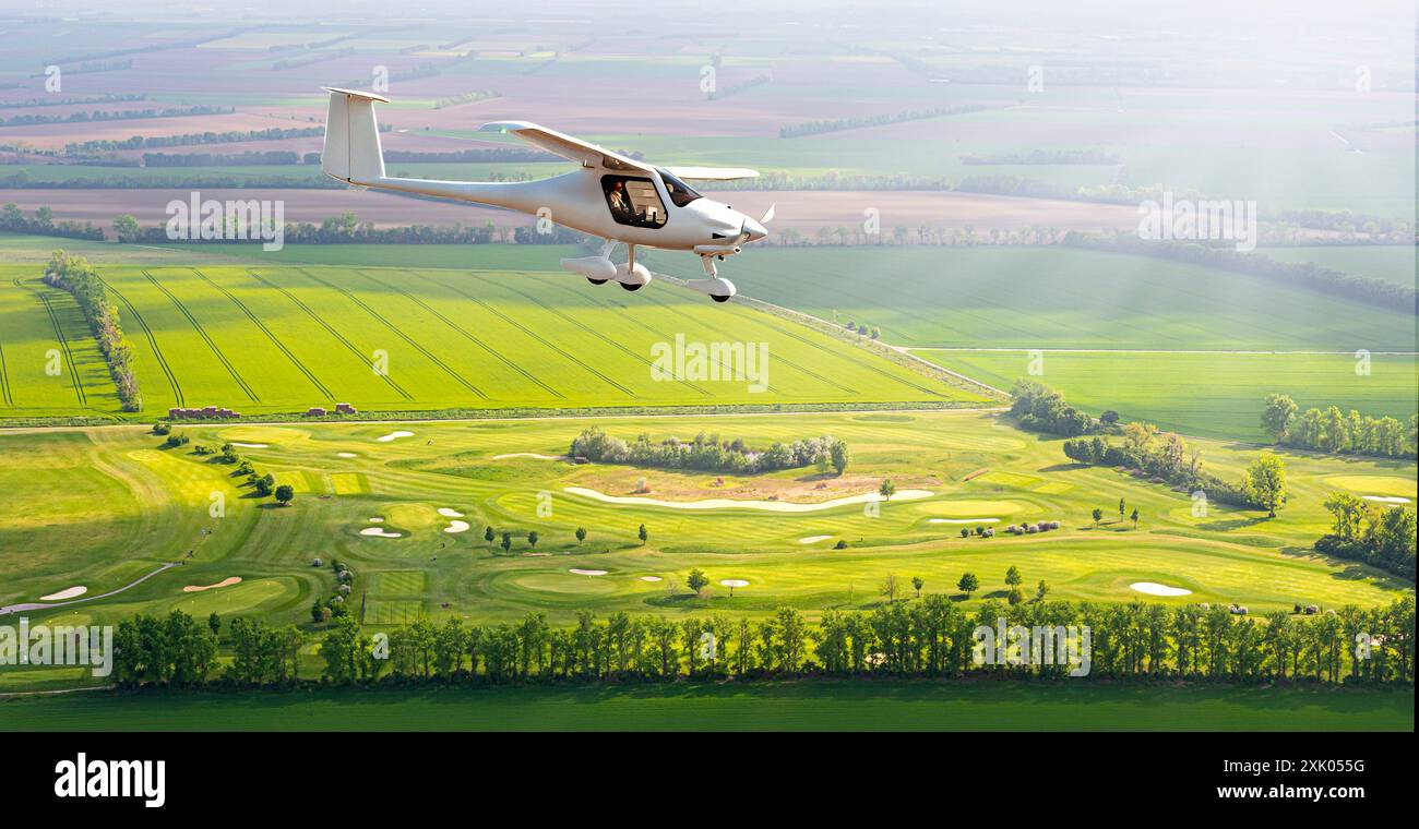 Light-engine plane flies in the morning sky clouds at dawn over the ...