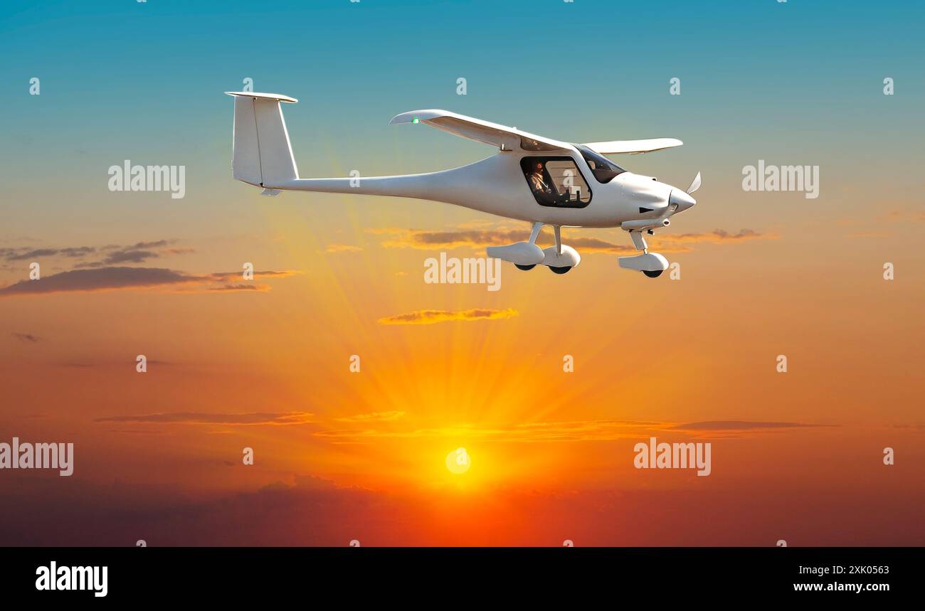 Light-engine plane flies in the sunrise with silver lining and cloud on ...