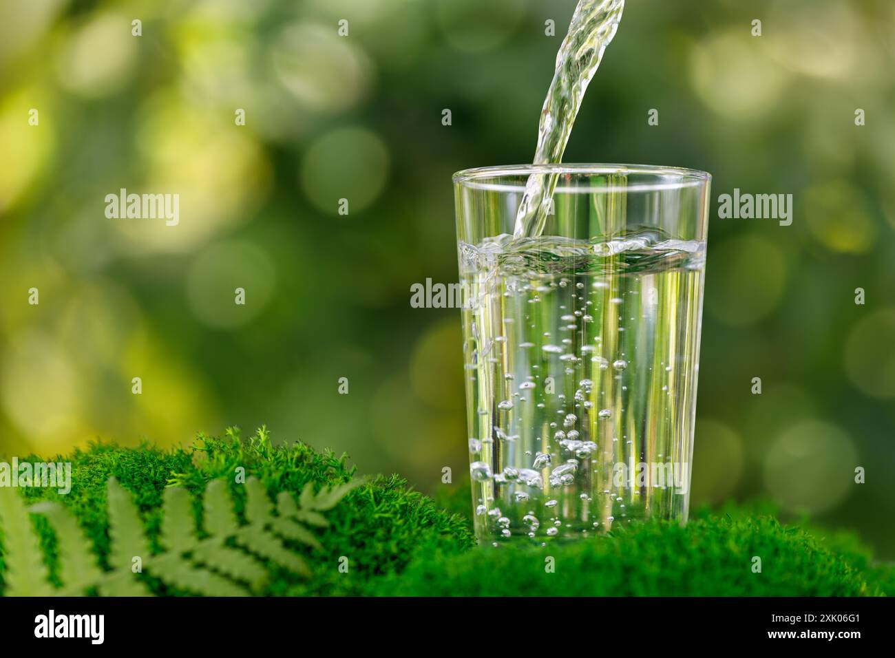 water pouring into glass on moss with green natural background Stock ...
